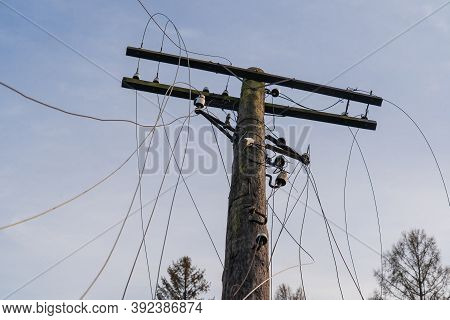 Old Tilted Electric Pole. The Wires Are Cut And Loose. There Is A Blue ...