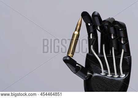The Black Mechanical Arm Of The Robot Holds A Cartridge With A Bullet ...