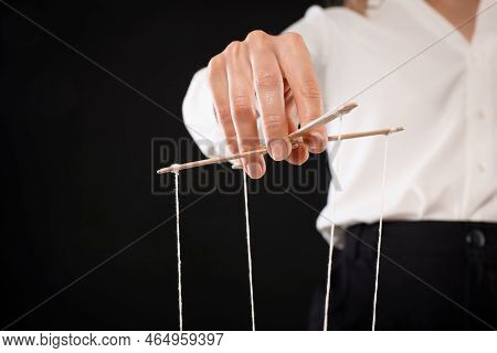 Hand Holding Puppet Strings