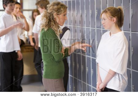 Teen Girl Being Told Off By Teacher In School Corridor Stock Photo ...