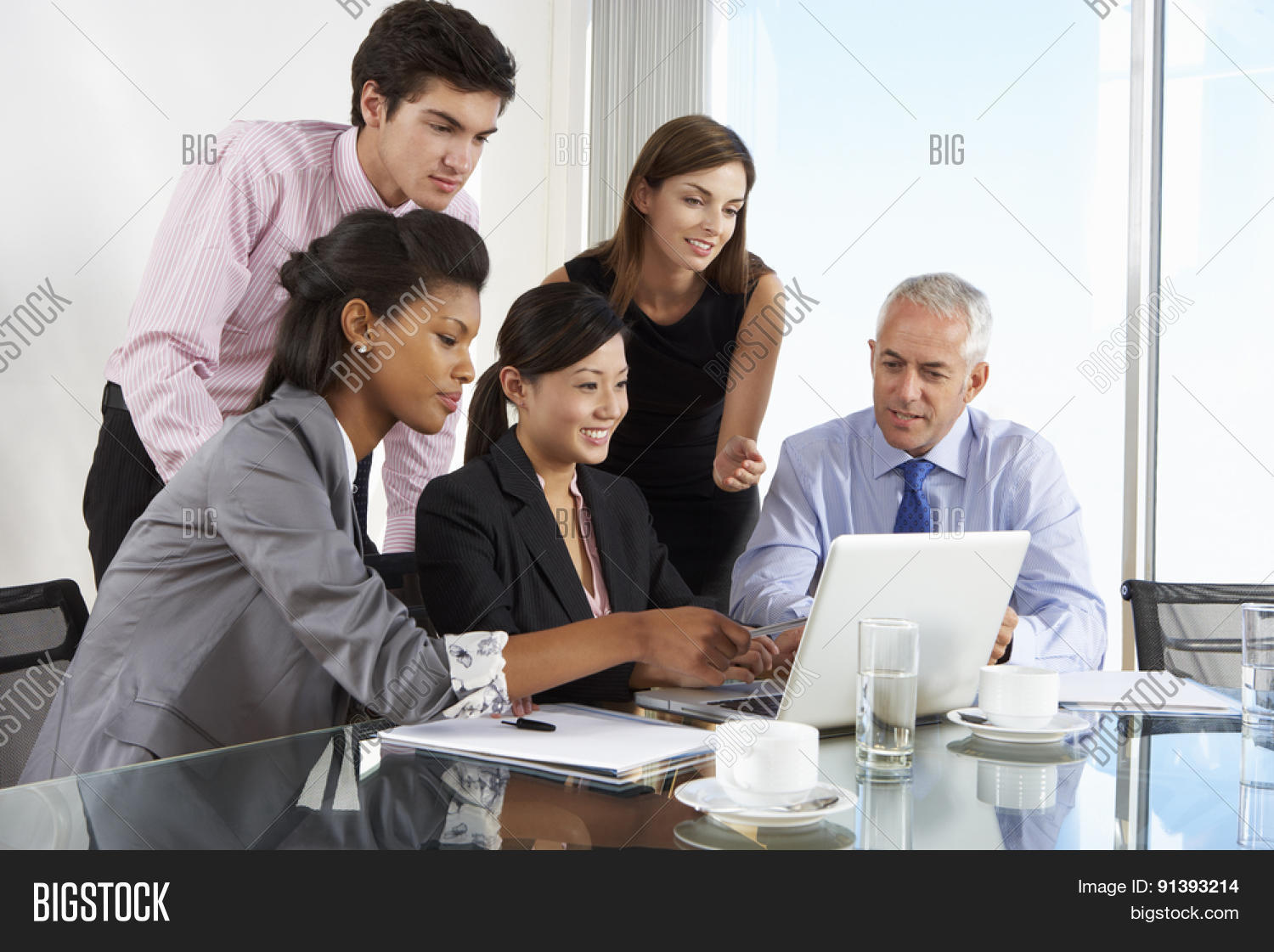 Group Of Business People Having Meeting Around Laptop At Glass Table ...