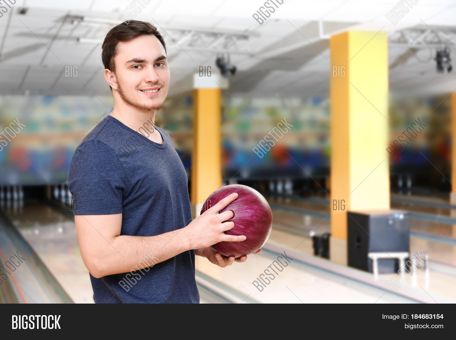 Handsome young man with ball in bowling club Stock Photo & Stock Images ...